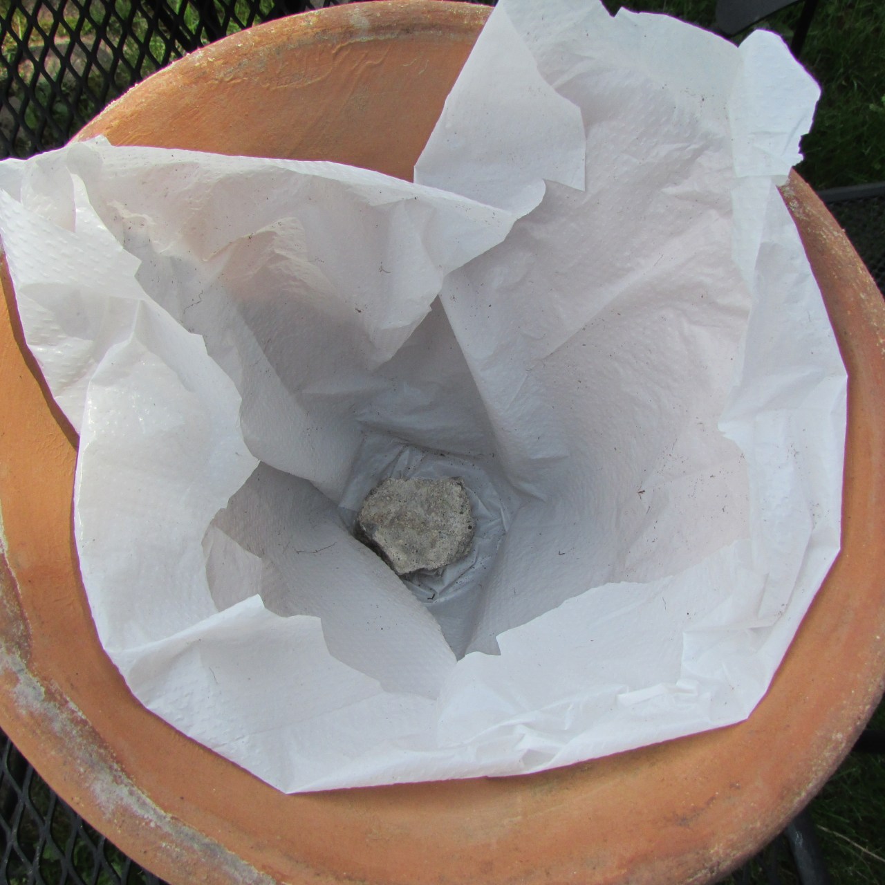 Line porous terracotta pots with tall kitchen trash bags before ...